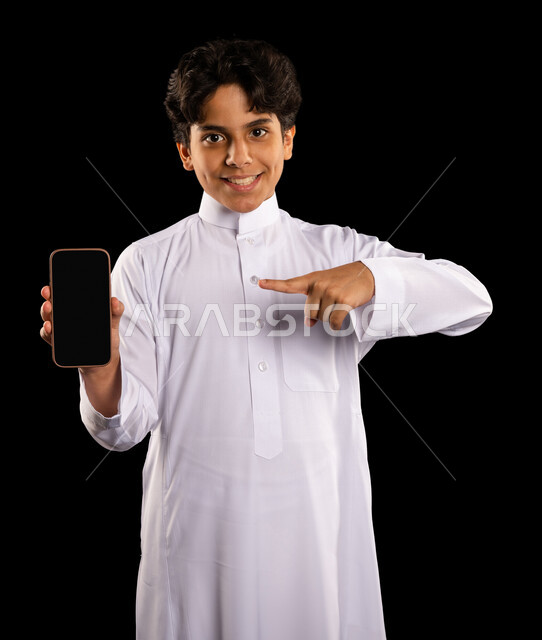 Portrait of a Saudi Arabian Gulf boy wearing Saudi dress, holding a ...