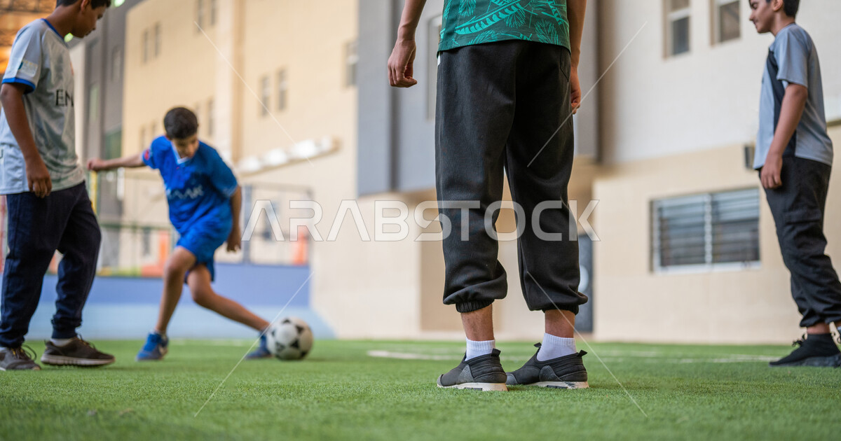 Saudi Gulf Arab students playing football in the school playground ...