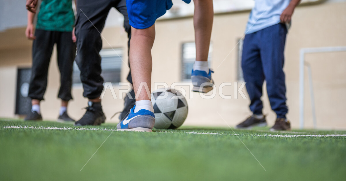 Saudi Gulf Arab students playing football in the school playground ...