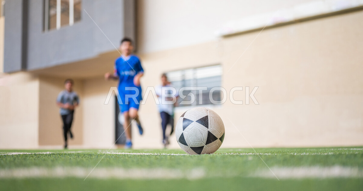 Saudi Gulf Arab students playing football in the school playground ...