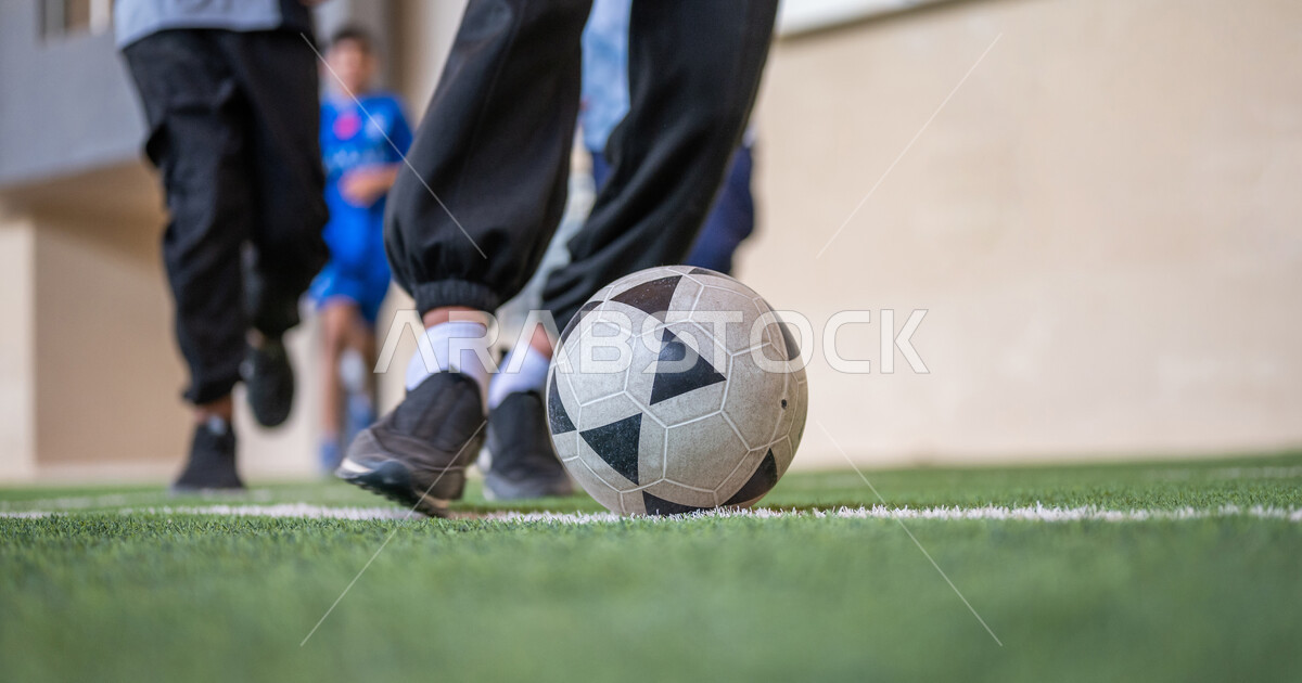 Saudi Gulf Arab students playing football in the school playground ...
