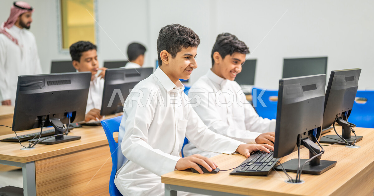 Saudi Arab Gulf teacher in the computer lab, teaching students how to ...