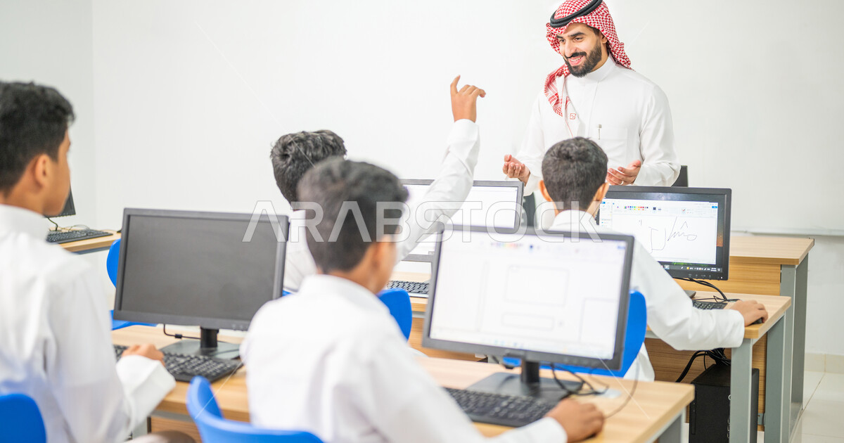 Saudi Arab Gulf teacher in the computer lab, teaching students how to ...