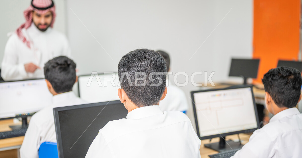 Saudi Arab Gulf teacher in the computer lab, teaching students how to ...