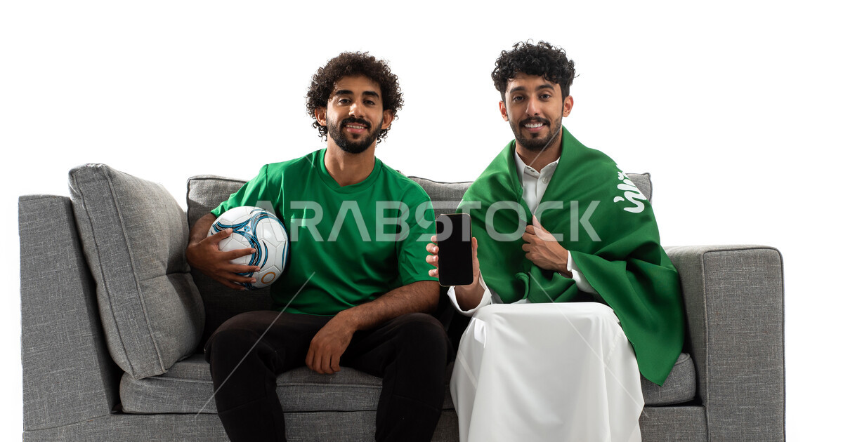 Portrait of two Saudi Arab Gulf youths enjoying watching the football ...