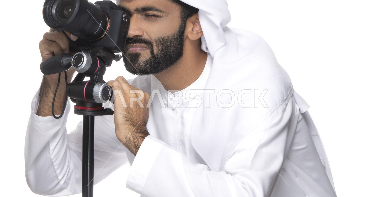 بورتريه لشاب عربي خليجي إماراتي ، يحمل بيده كاميرا التصوير ، يلتقط ...