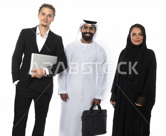 An Emirati business team and a man in a formal suit standing in front ...