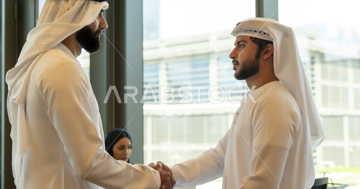 Two Arab Emirati Gulf businessmen shaking hands, agreement and ...
