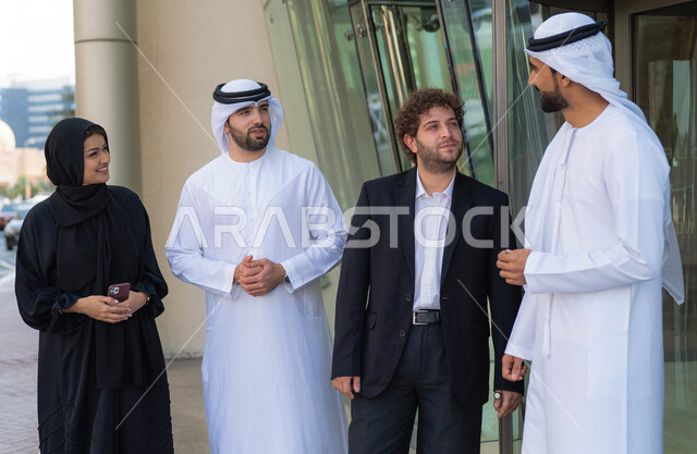 Arab Gulf Emirati work team outside the company building, dialogue and ...