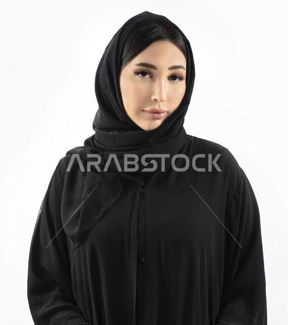 Portrait of a close-up of a veiled Emirati Arab Gulf woman, looking at ...