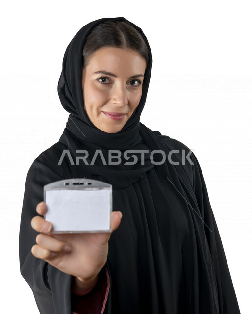 Portrait of a smiling, veiled Emirati Arab Gulf woman, holding a blank ...