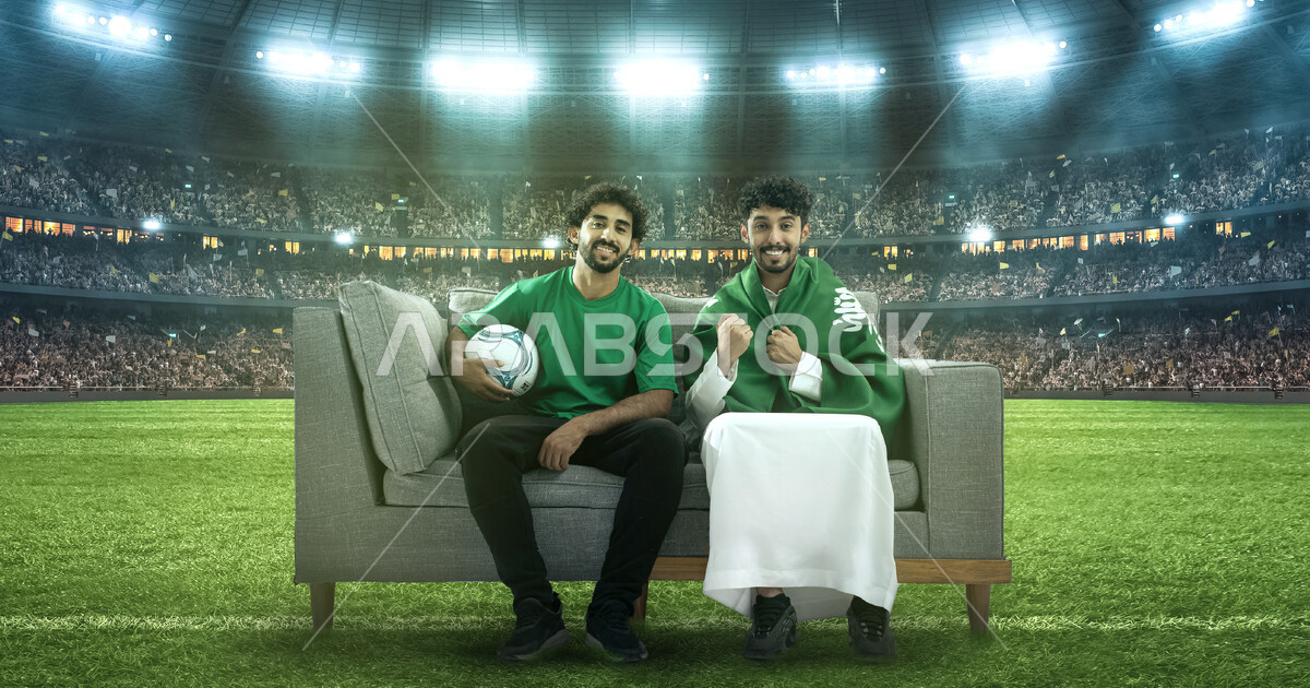 Two Saudi Arabian Gulf youths enjoying watching a football match, a ...