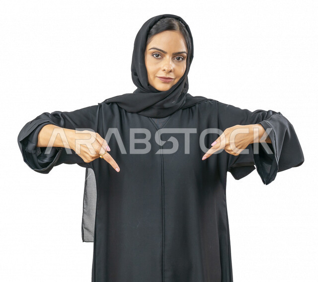 Portrait of an Arab Emirati Gulf woman wearing abaya and hijab, two hands gestures pointing to ...