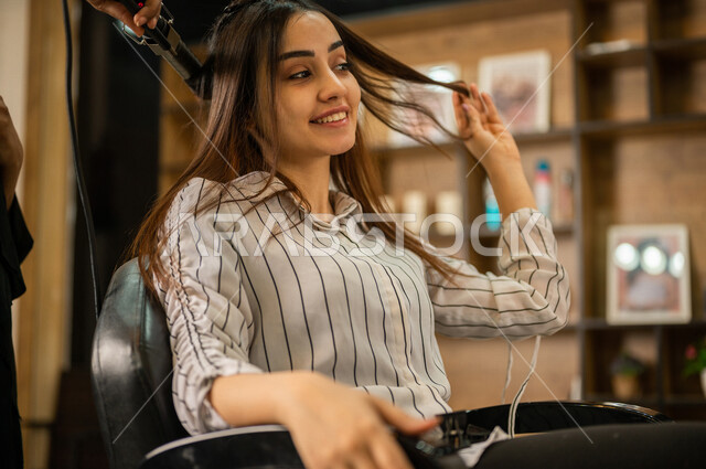 A Saudi Arabian Gulf woman in a women's beauty salon, a hairdresser ...