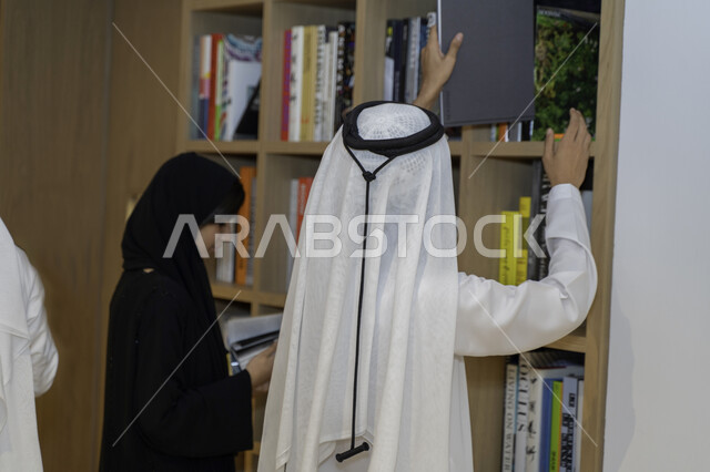 Emirati Gulf Arab students in the university library, reading a book ...