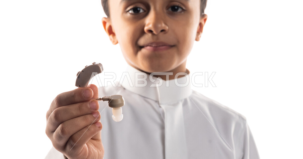 Portrait of a Saudi Arabian Gulf boy, deaf, holding in his hand a ...