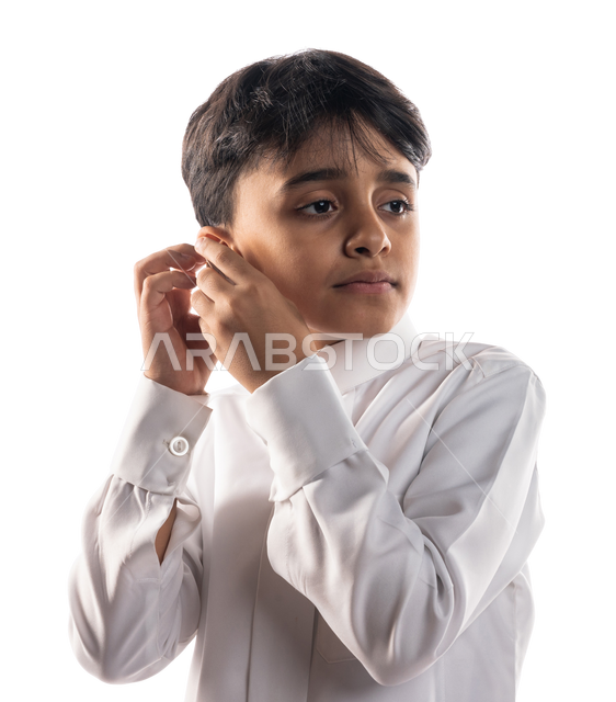 Portrait of a Saudi Arabian Gulf boy, deaf, wearing a medical earphone ...