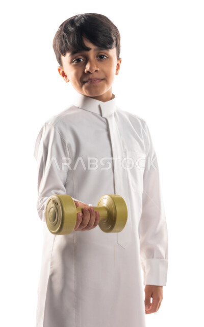 Portrait of a Saudi Arabian Gulf boy, exercising with dumbbells ...