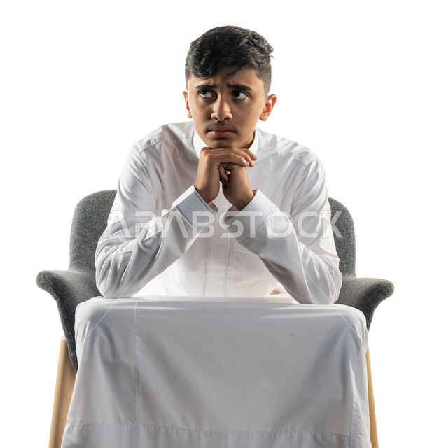 Portrait of a Saudi Arabian Gulf boy, sitting on a chair, facial ...