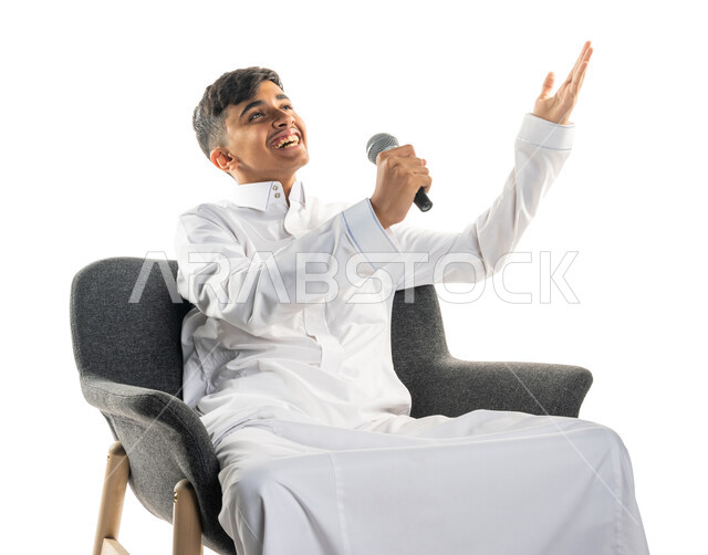 Portrait of a Saudi Arabian Gulf boy, sitting on a chair, holding a ...