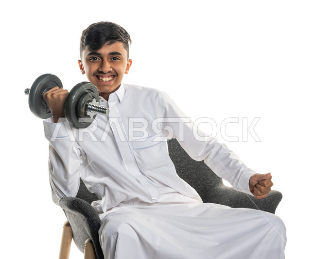 Portrait of a Saudi Arabian Gulf boy sitting on a chair, exercising ...