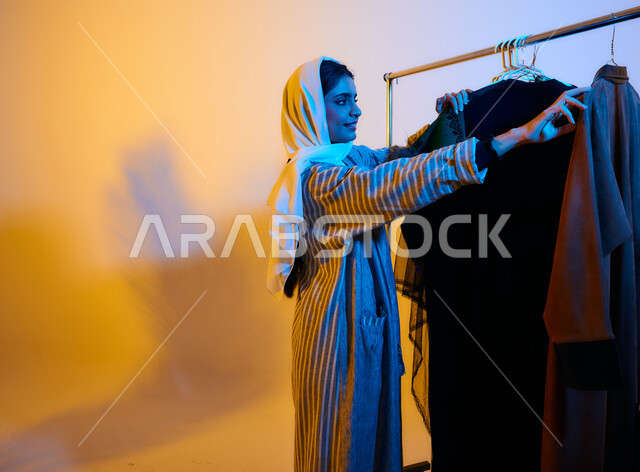 Portrait of a Saudi Arab Gulf woman wearing an elegant colorful abaya ...