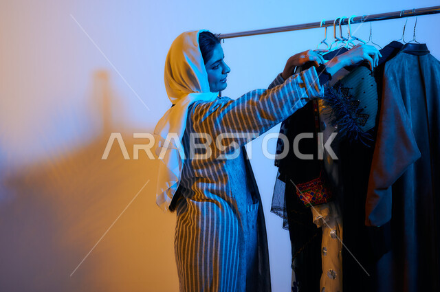 Portrait of a Saudi Arab Gulf woman wearing an elegant colorful abaya ...