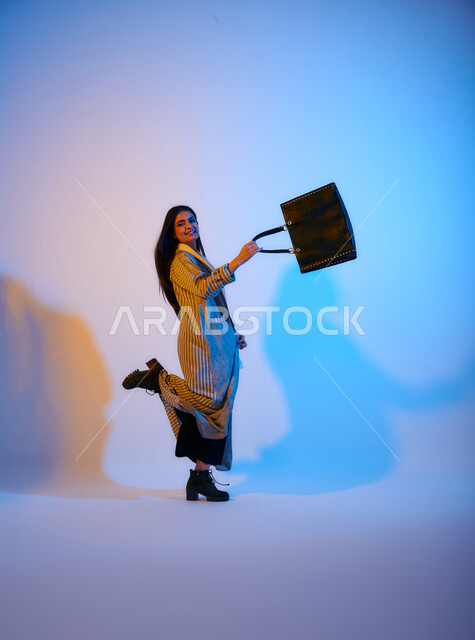 Portrait of a Saudi Arabian Gulf woman wearing an elegant colorful ...