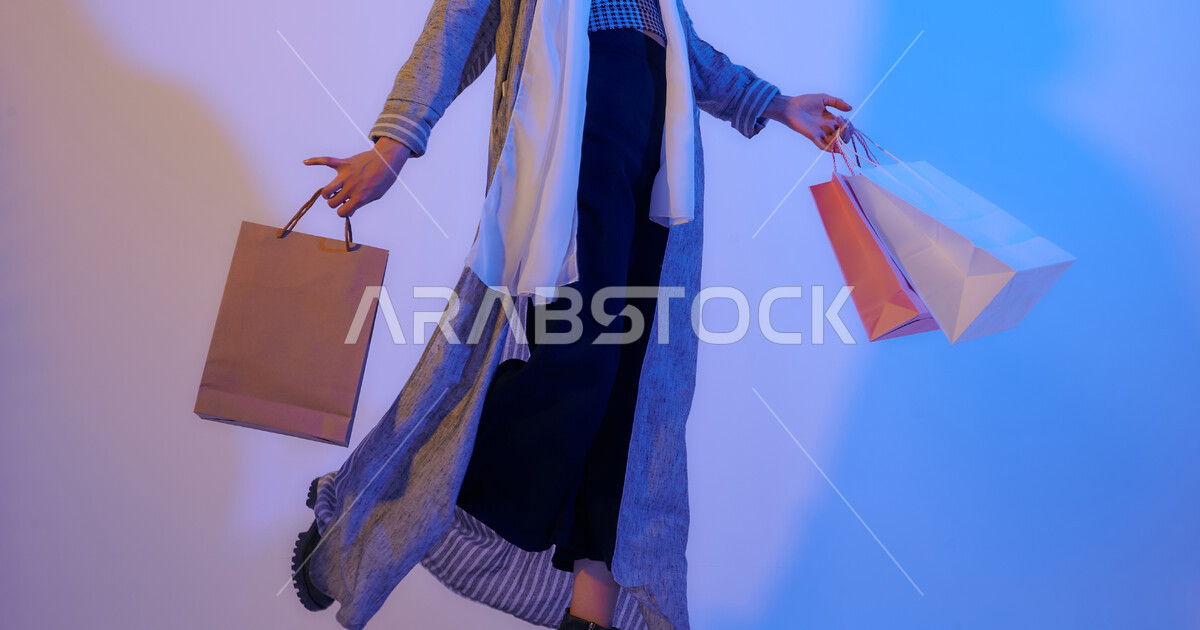 بورتريه لإمرأة عربيه خليجية سعوديه ترتدي عباءه ملونه أنيقه تحمل بيدها ...