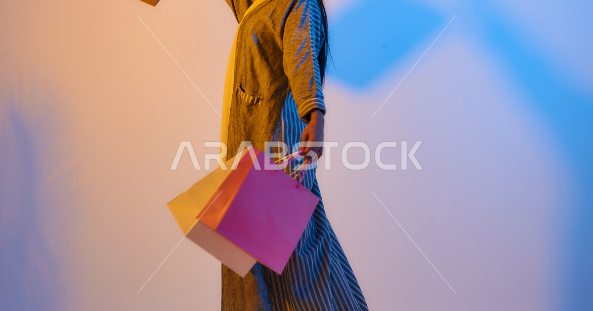 بورتريه لإمرأة عربيه خليجية سعوديه ترتدي عباءه ملونه أنيقه تحمل بيدها ...