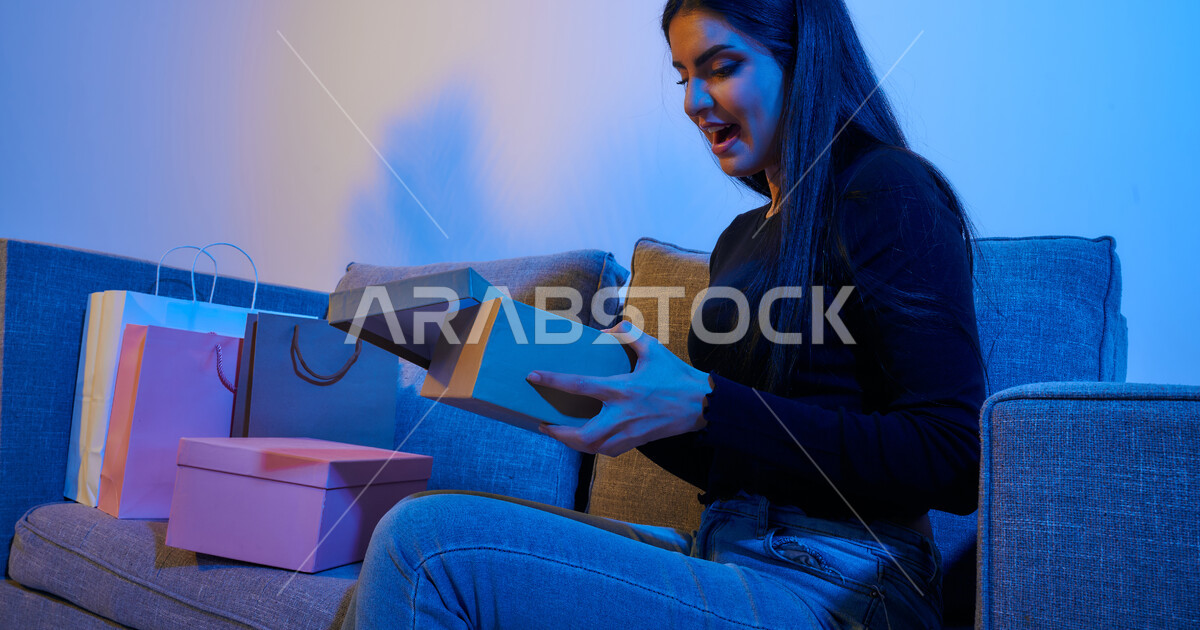 بورتريه لإمرأة عربيه خليجية سعوديه تحمل بيدها علب هدايا ملونه التسوق