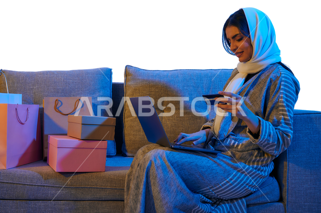 إمرأة عربيه خليجية سعوديه تحمل بيدها جهاز الحاسوب المحمول التسوق