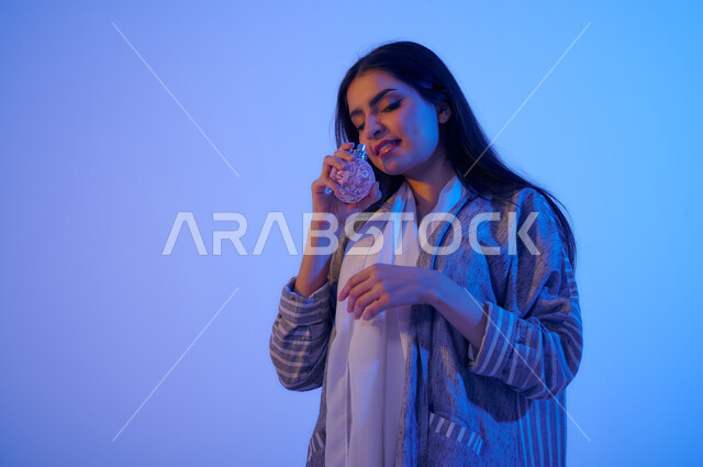 Portrait of a Saudi Arabian Gulf woman applying perfume, the concept of ...