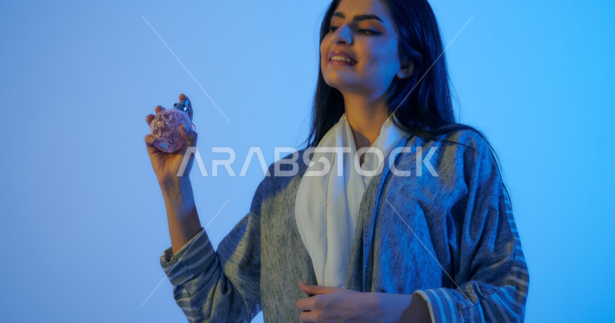 Portrait of a Saudi Arabian Gulf woman applying perfume, the concept of ...