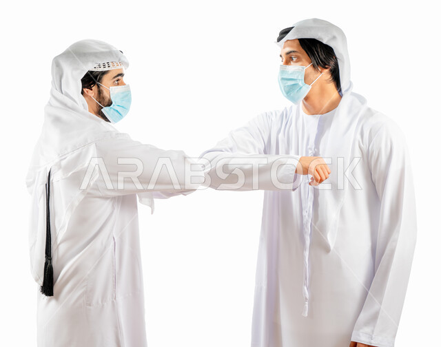 Portrait of two Arab Gulf Emirati businessmen shaking hands, wearing a ...