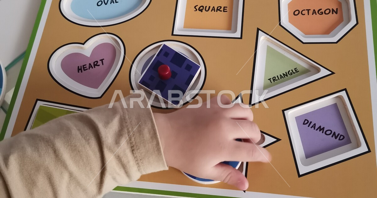 A close-up of a young child playing with recreational games ...