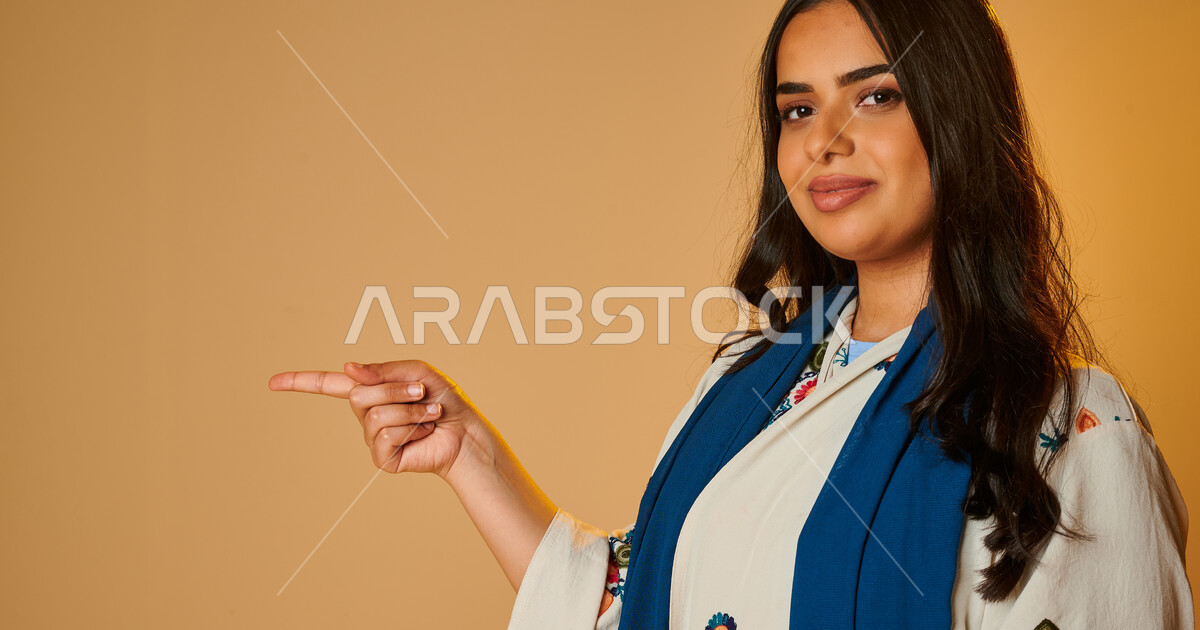 بورتريه لامرأة عربية خليجية سعودية تشير باصبع السبابة نحو شيء ما ...