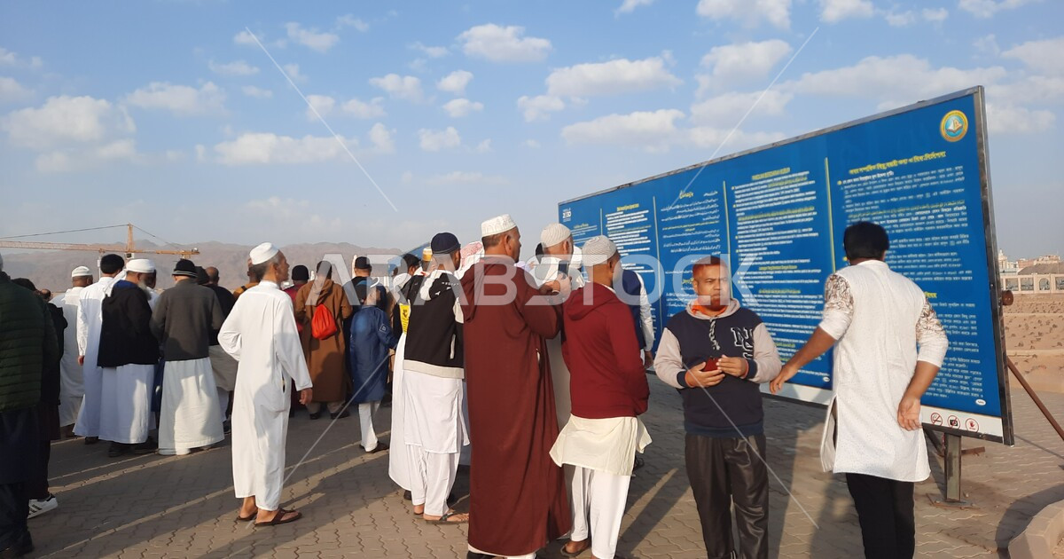 Muslims gathered in front of a signboard of the Islamic Baqi Cemetery ...