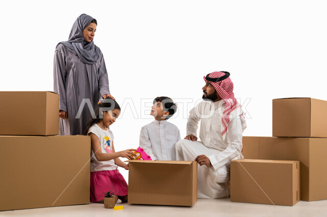 Portrait of a Saudi Gulf Arab family unpacking and arranging boxes of ...