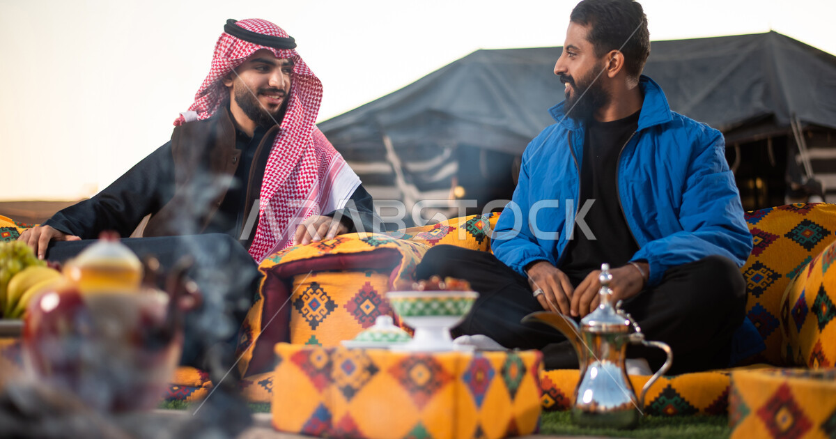 Two young Saudi Arabian Gulf men enjoying a wild camping trip, wearing ...