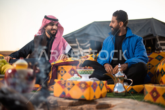 Two young Saudi Arabian Gulf men enjoying a wild camping trip, wearing ...