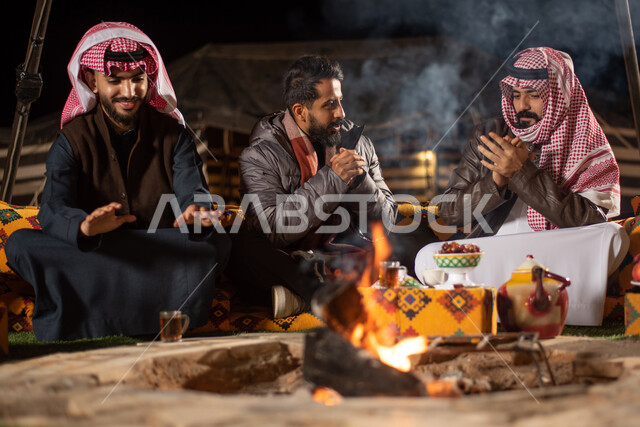 A group of Saudi Gulf Arab friends dressed in warm winter clothes with ...