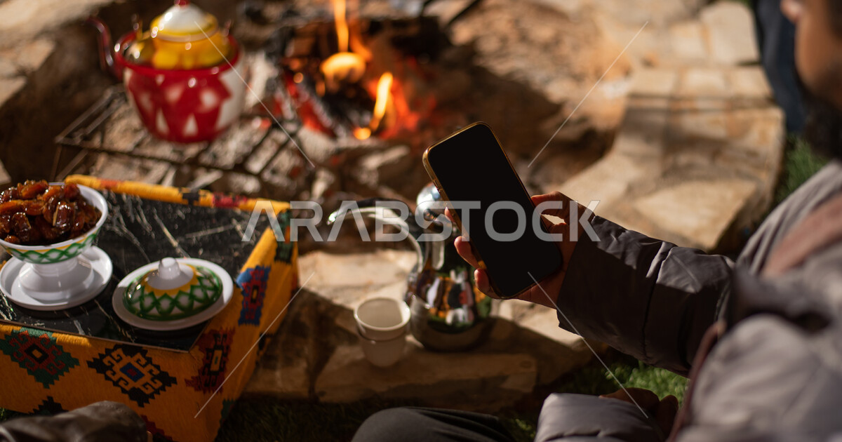 A close-up of a Saudi Arab Gulf man sitting in front of a firewood ...
