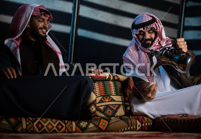 Two young Saudi Arabian Gulf men dressed in warm winter clothes, good ...