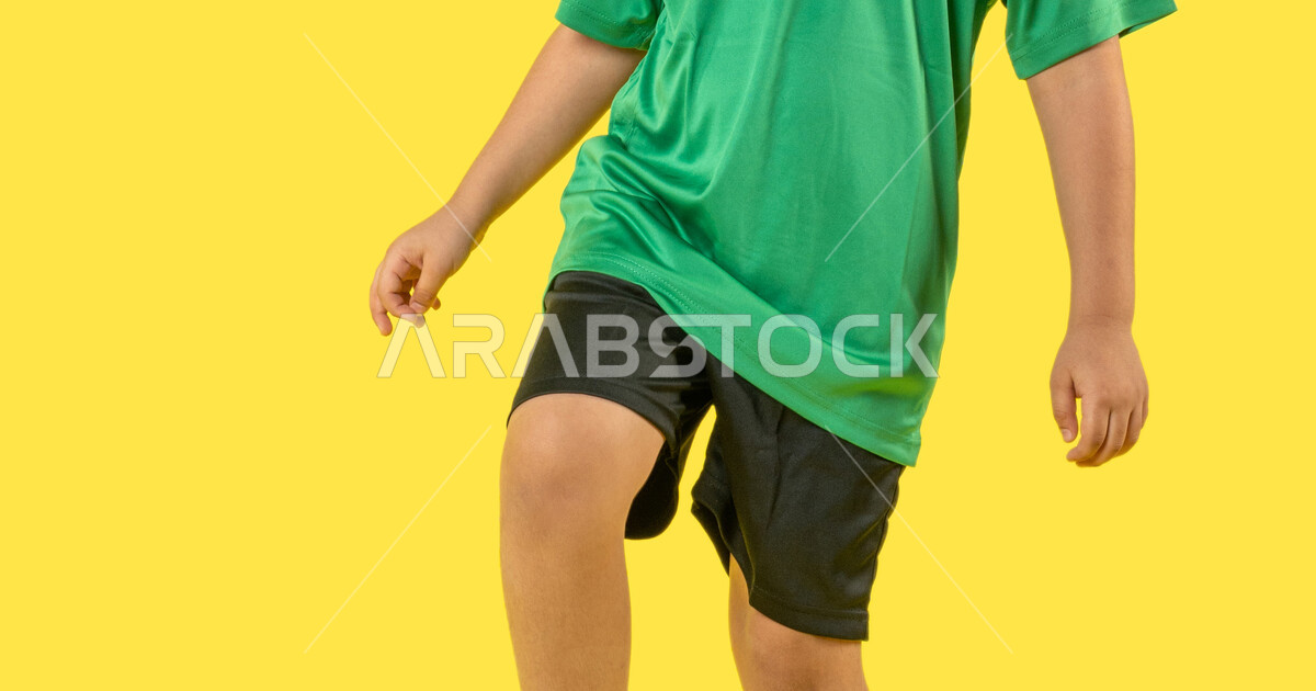 Playing football, a portrait of a Saudi Arabian Gulf boy wearing sports ...