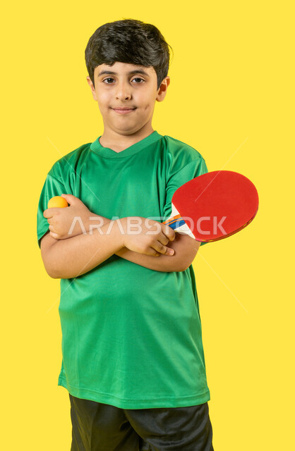 Portrait of a Saudi Arabian Gulf boy wearing sports clothes and holding ...