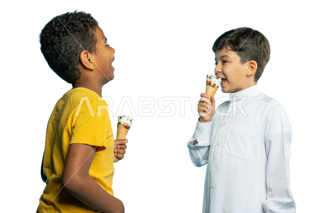 Portrait of two Saudi Arabian Gulf children enjoying eating ice cream ...