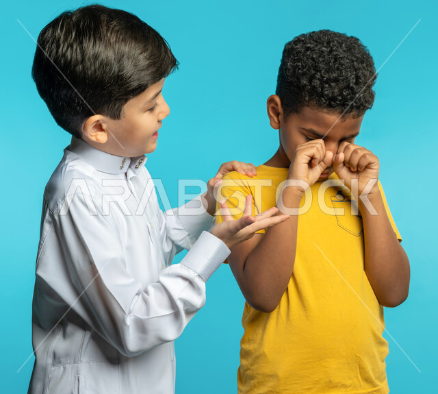 Portrait of a Saudi Arabian Gulf child consoling his sad friend, trying ...