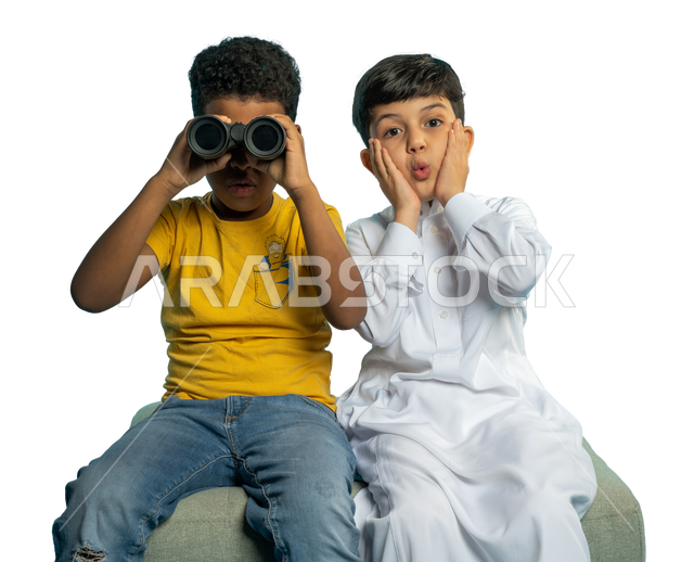 Portrait of two Saudi Arabian Gulf children looking through binoculars ...