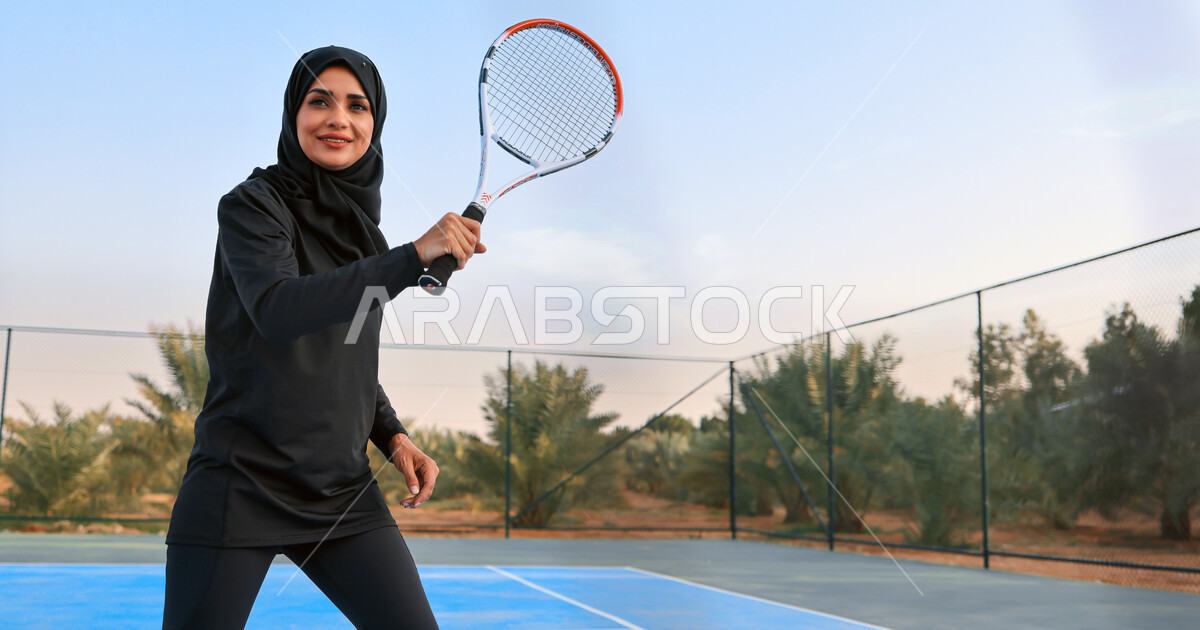 A Saudi Arab Gulf woman playing tennis, playing tennis in public courts ...